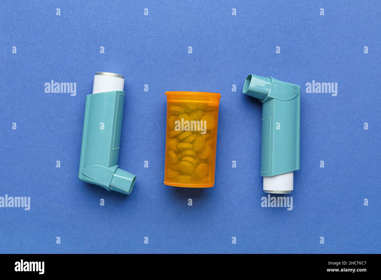 Asthma inhalers and jar of pills on blue background Stock Photo - Alamy