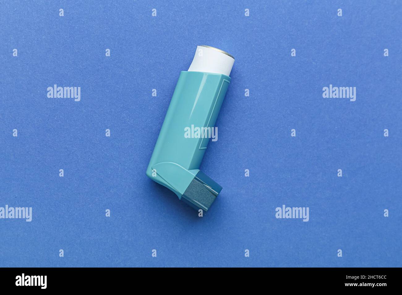 Asthma inhaler on blue background Stock Photo - Alamy