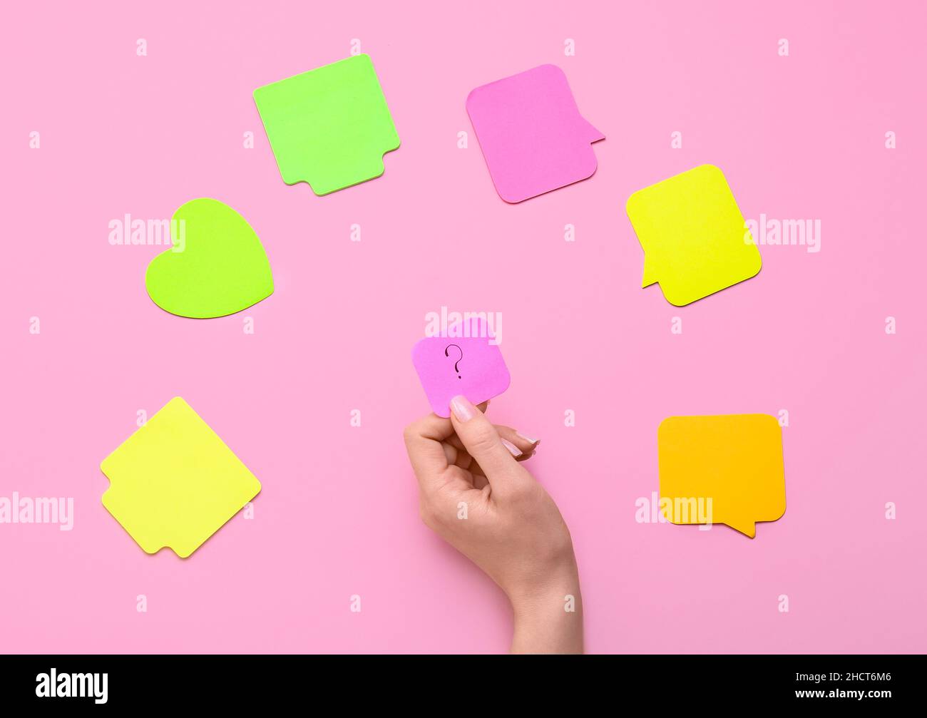 Woman holding sticky note with question mark on pink background Stock ...