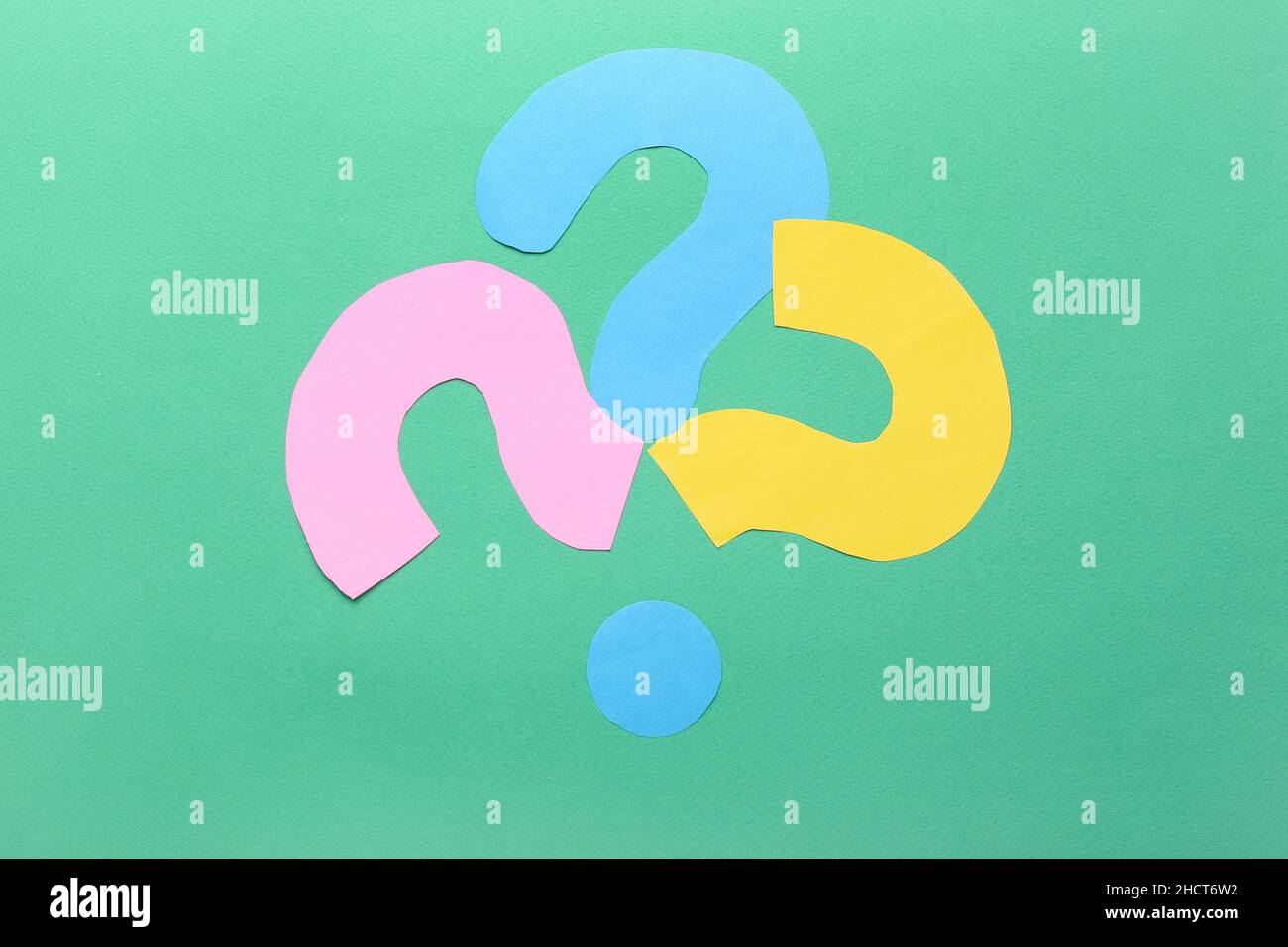 Question marks made of paper on green background Stock Photo - Alamy