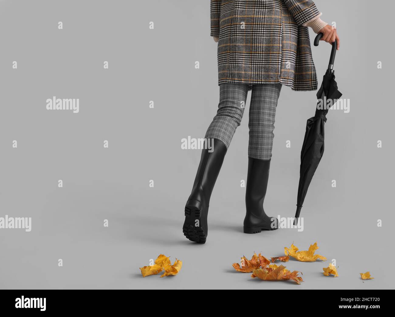 Elegant woman in gumboots walking on grey background, closeup Stock ...