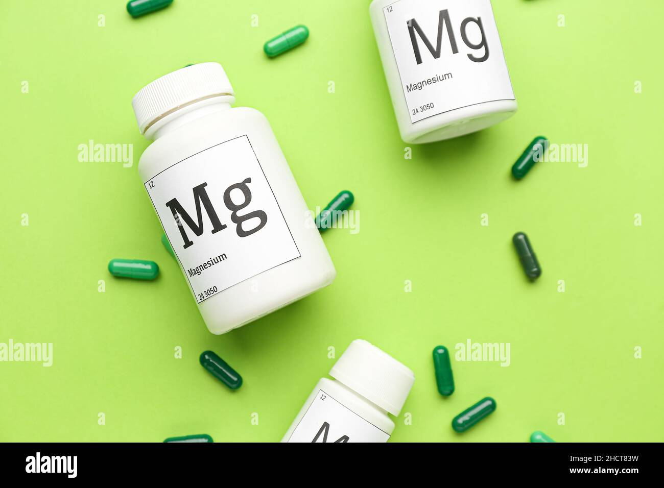 Bottles of magnesium pills on green background Stock Photo - Alamy
