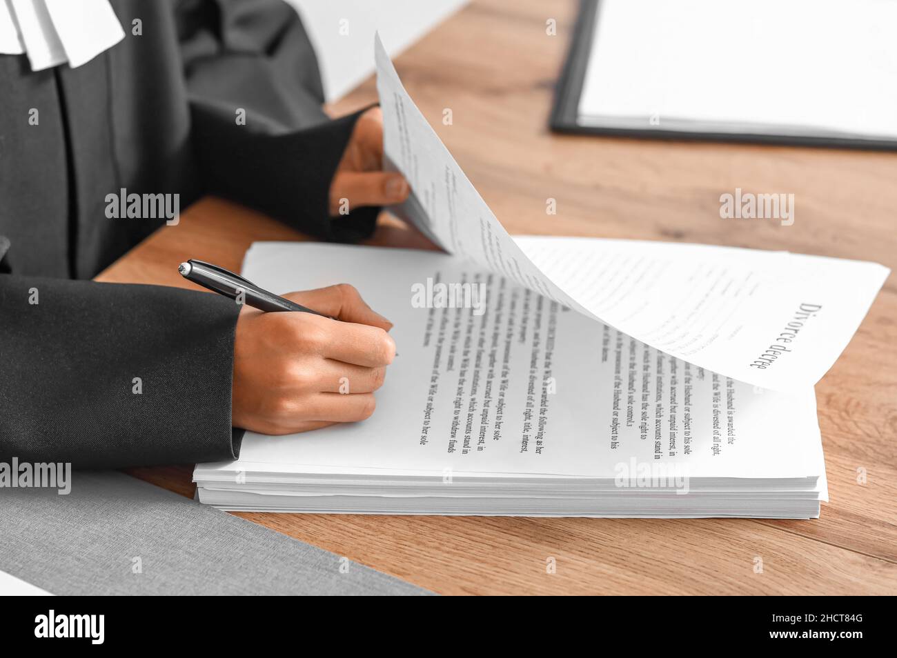 Female judge signing documents at workplace in courtroom Stock Photo ...