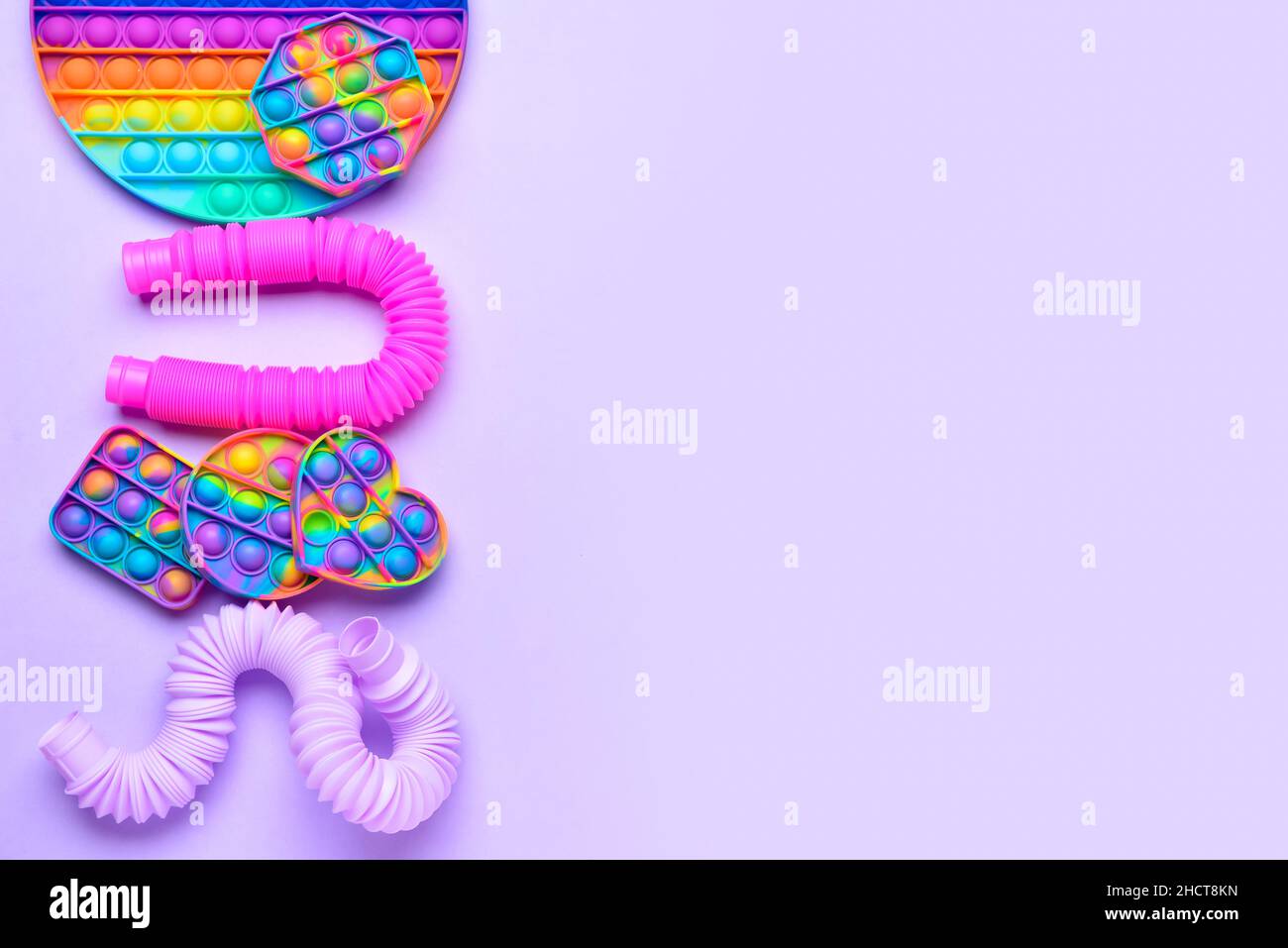 Colorful Pop Tubes and Pop it fidget toys on purple background Stock ...