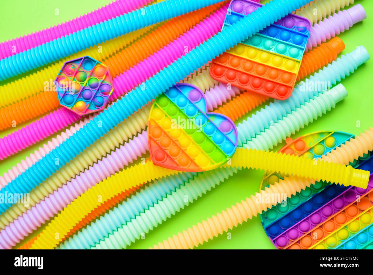 Colorful Pop Tubes and Pop it fidget toys on green background Stock ...