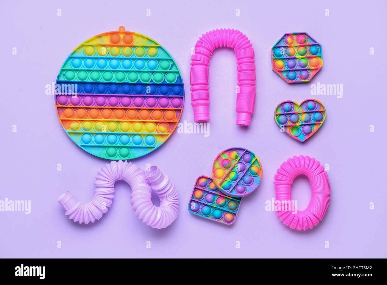 Colorful Pop Tubes and Pop it fidget toys on purple background Stock ...