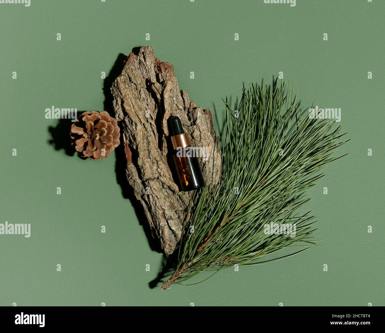 Composition with bottle of essential oil, tree bark, pine cone and ...