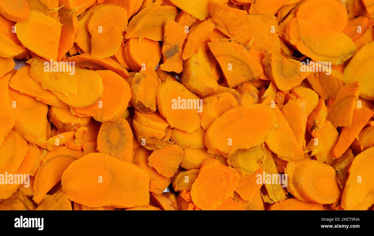 Overhead view of the cut down turmeric pieces put in direct sunlight ...