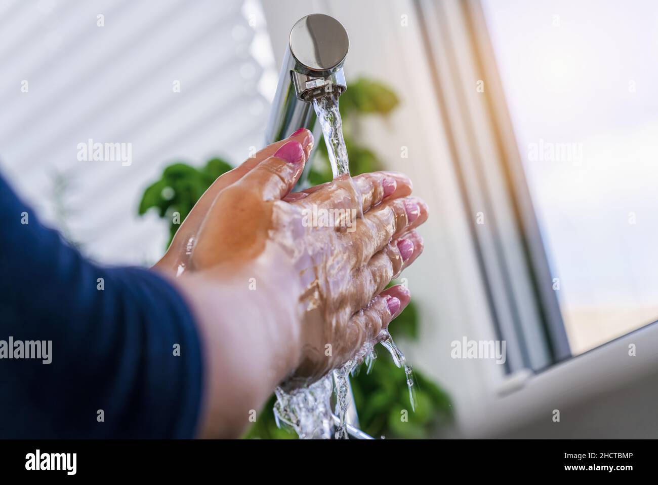 Hygiene concept. Washing hands with soap under the faucet with water ...