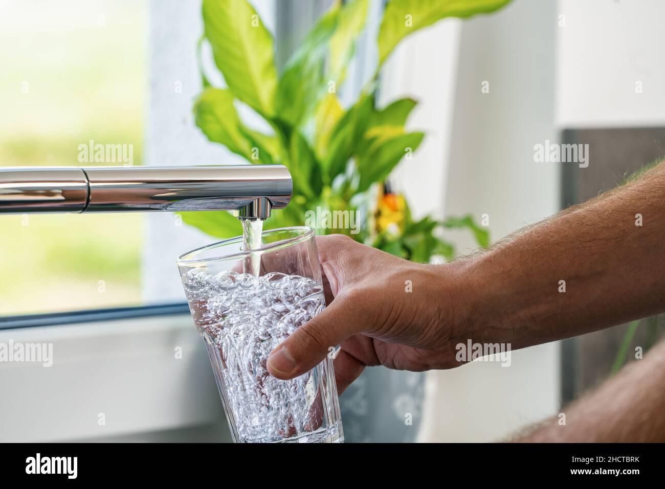 Glass filled with water from faucet Stock Photo - Alamy