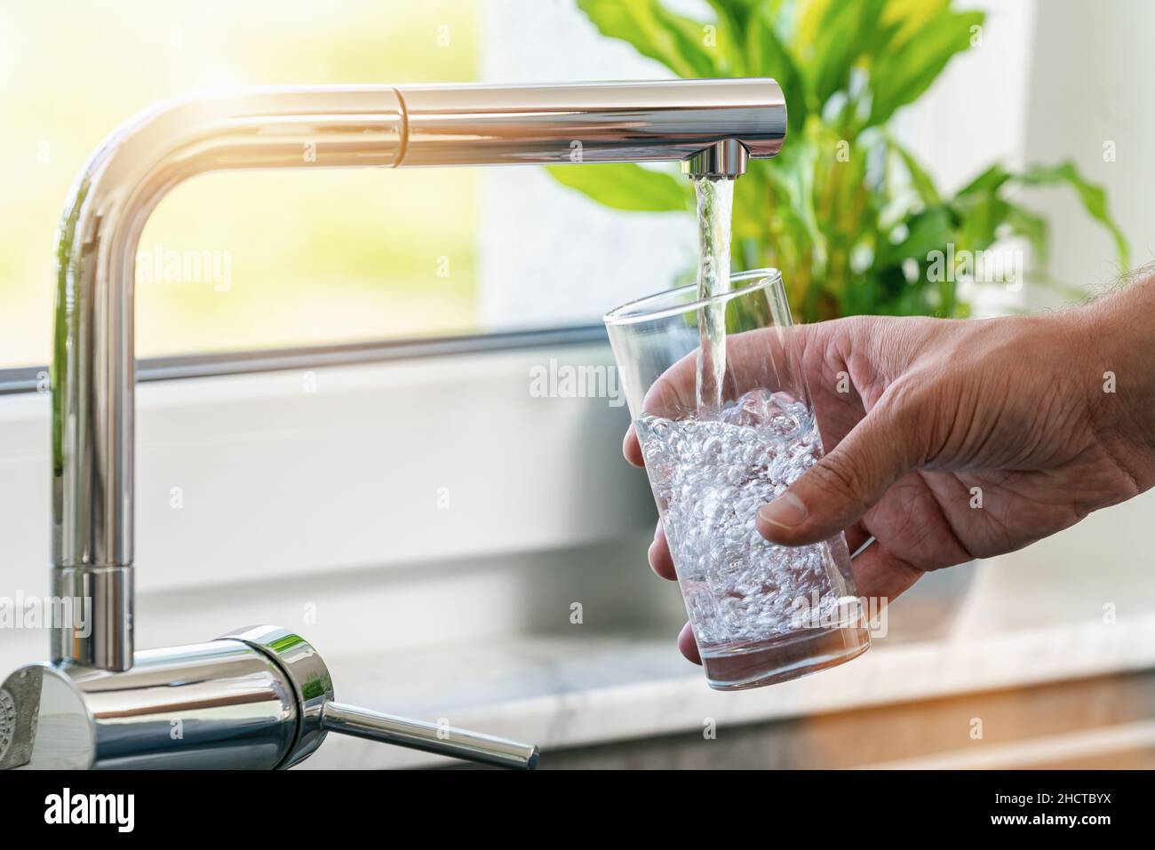 Filling glass of water from stainless steel kitchen faucet Stock Photo ...