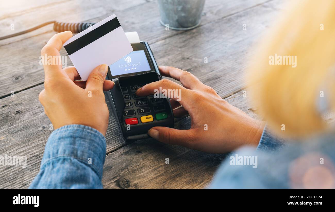 Close up of hand using credit card swiping machine to pay. Hand with ...