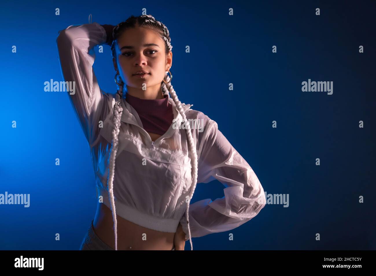 Urban session. Young caucasian woman with long white braids on a blue ...