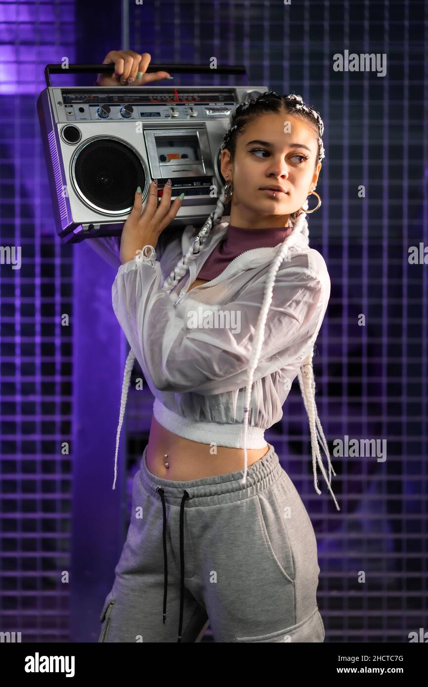 Young girl with white braids with a boombox on her shoulders, urban ...