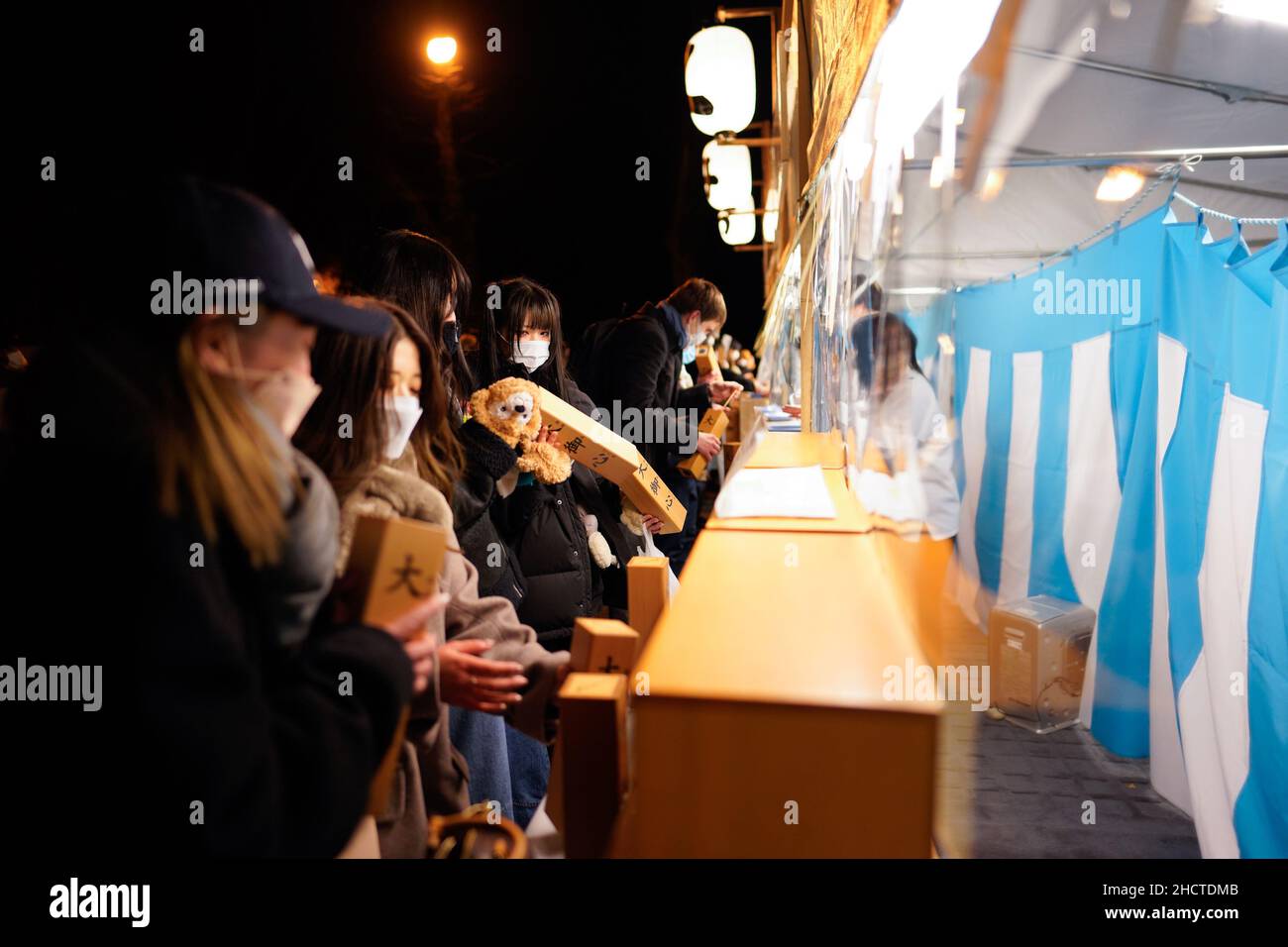 Tokyo, Japan. 1st Jan, 2022. People pray and draw divination sticks at ...
