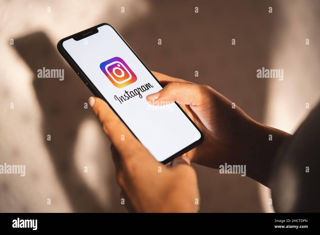 Woman hand holding iphone Xs with logo of instagram application ...