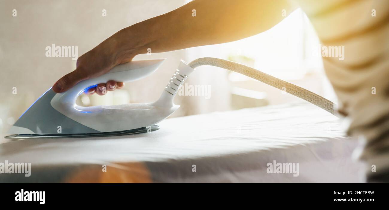 Women ironing clothes on ironing board in laundry room at home Stock ...