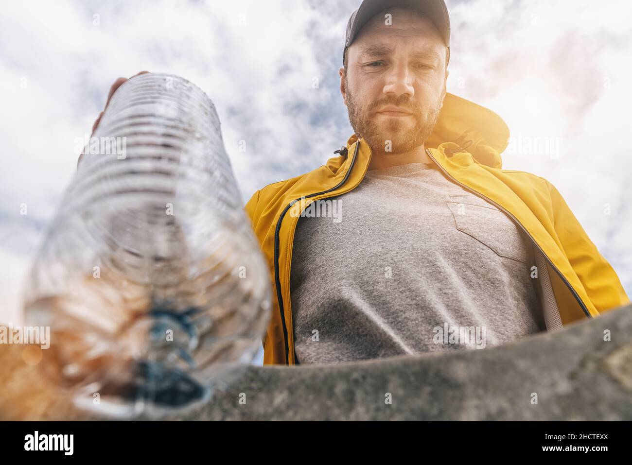man throw plastic bottle in to garbage Stock Photo - Alamy