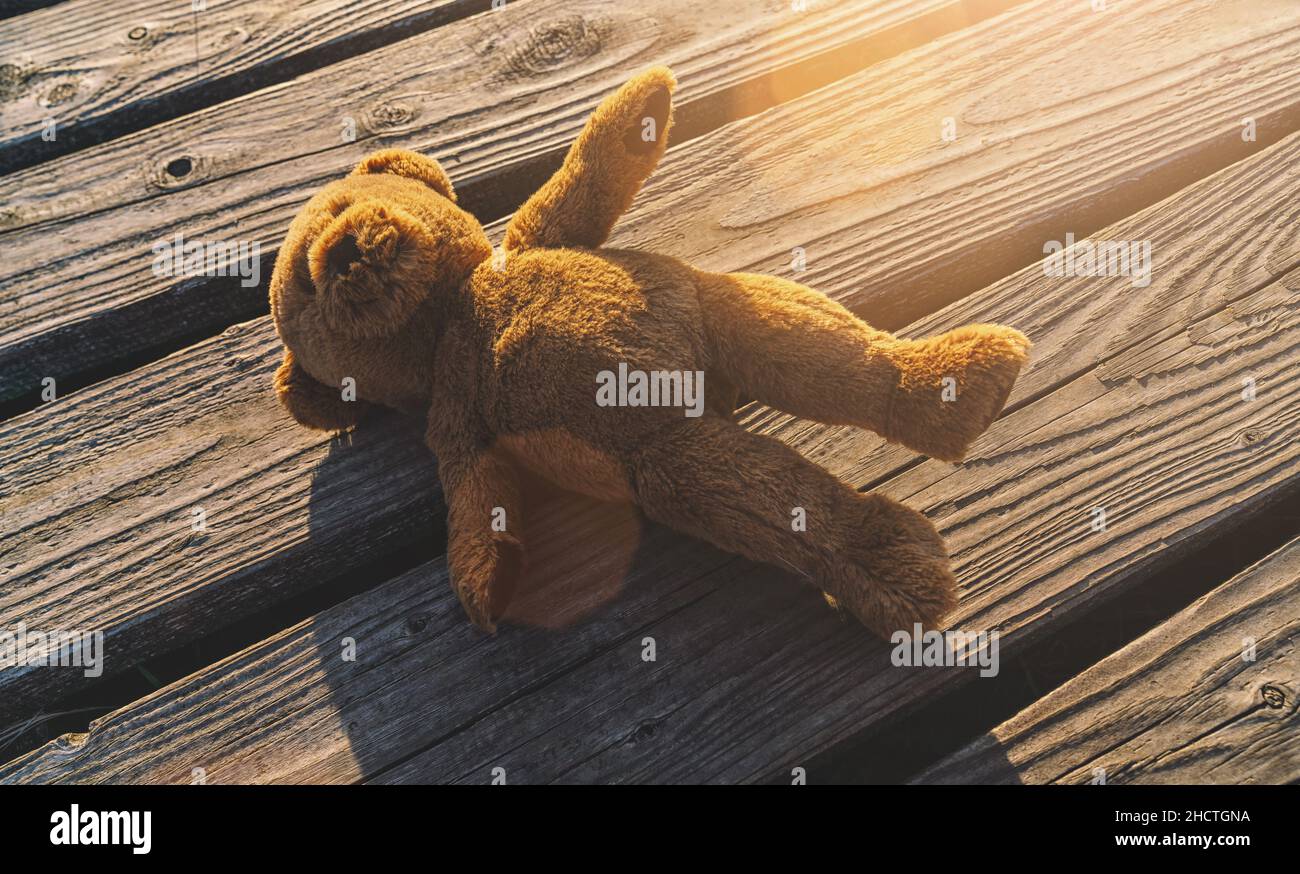 Lost teddy bear lying on a boardwalk Stock Photo - Alamy