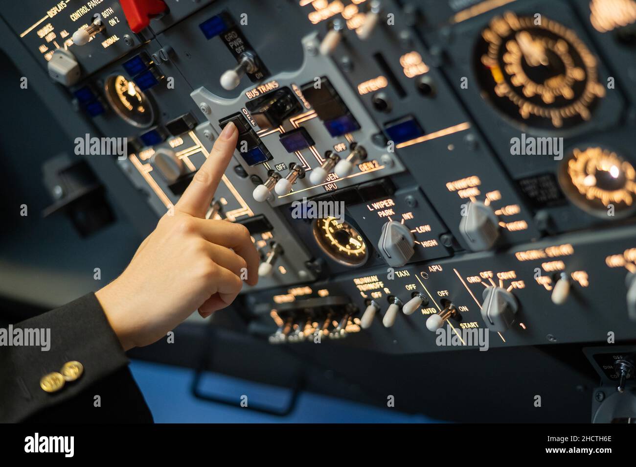 Close-up of a pilot's hand turning a toggle switch on the control panel ...