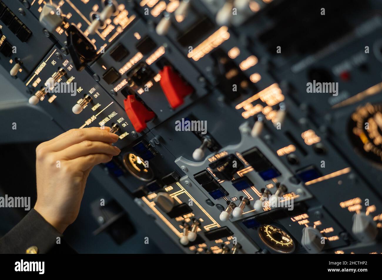 Close-up of a pilot's hand turning a toggle switch on the control panel ...