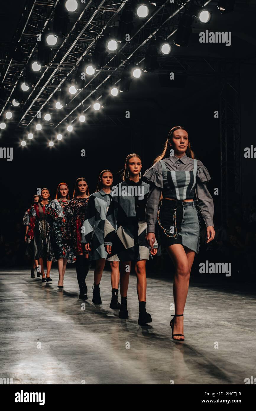 Young fashion models walking the final run at a Fashion show during ...