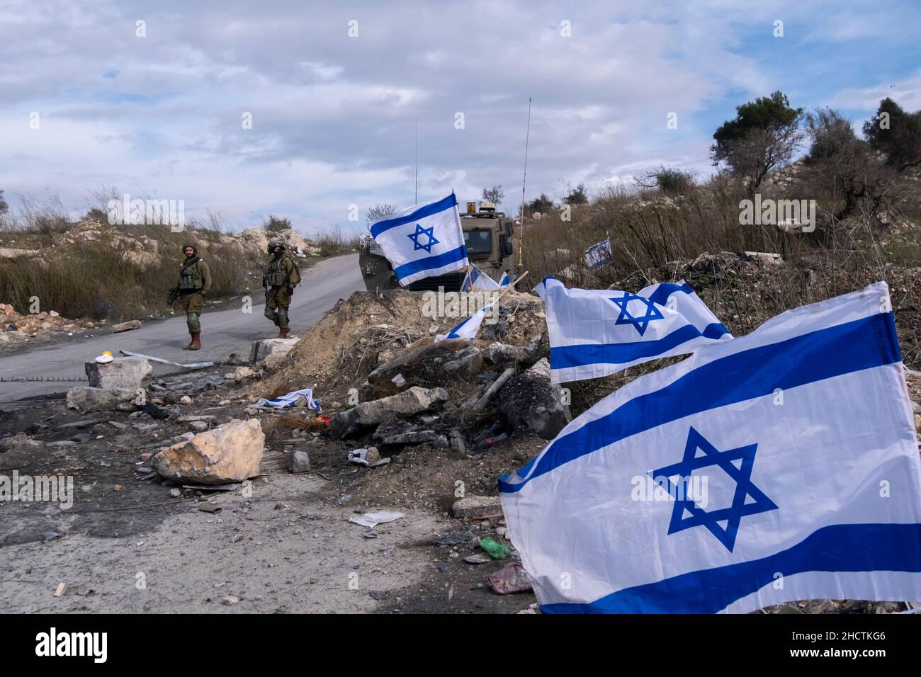 Israeli soldiers stand guard in an improvised checkpoint on the way to ...