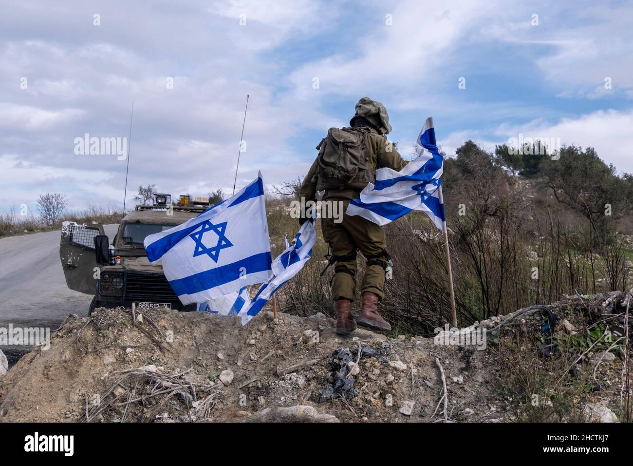 Israeli soldiers stand guard in an improvised checkpoint on the way to ...