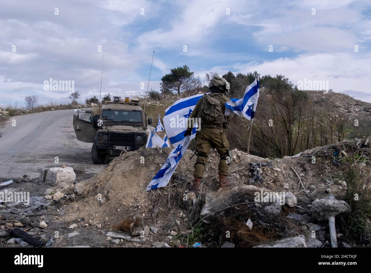 Israeli soldiers stand guard in an improvised checkpoint on the way to ...