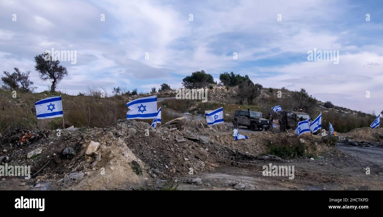 Israeli soldiers stand guard in an improvised checkpoint on the way to ...