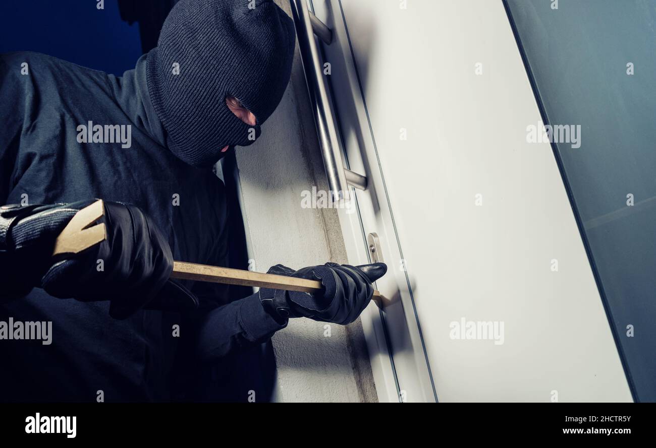 Burglar wearing black clothes and breaking in a house at night Stock ...