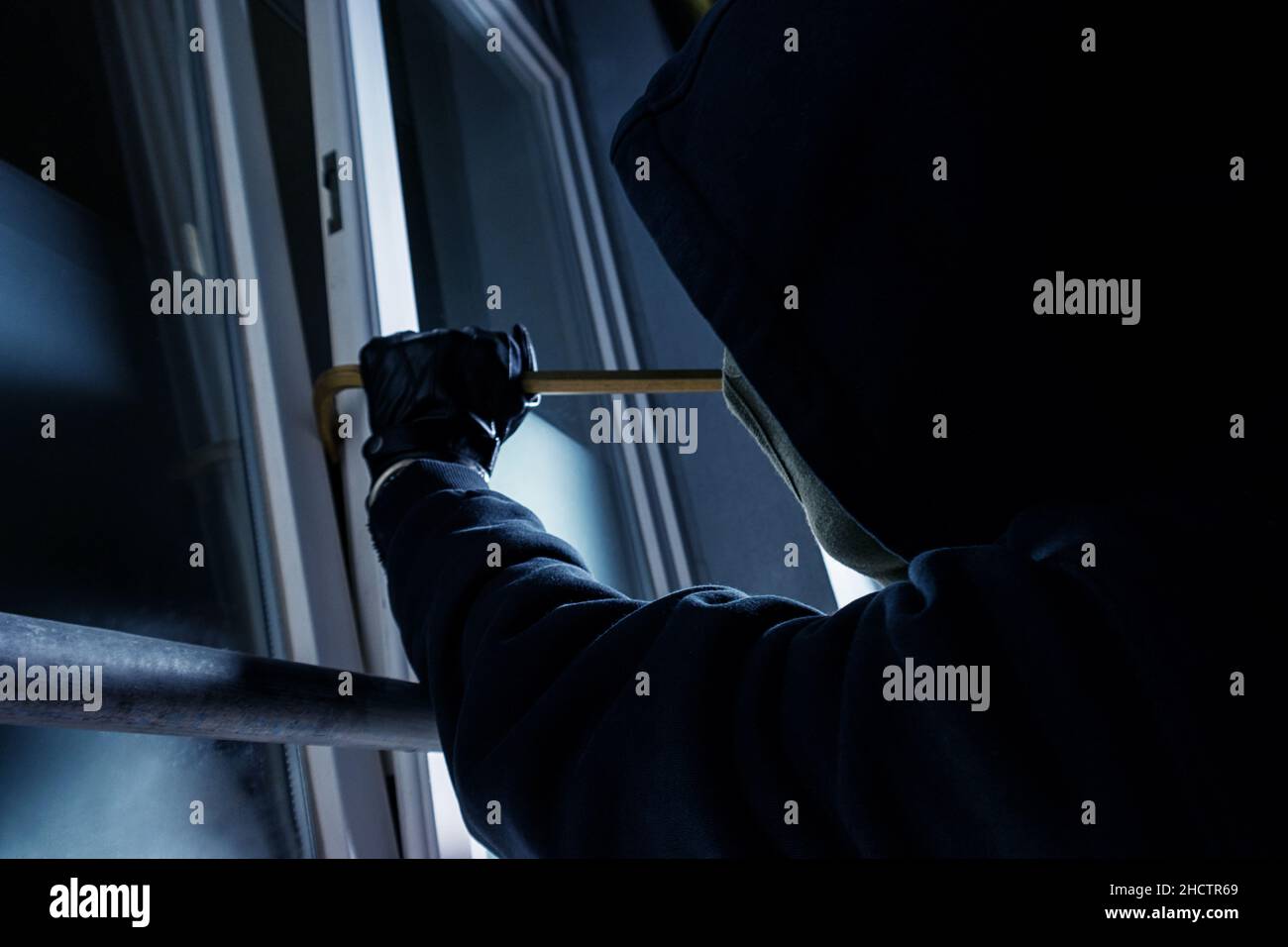 burglar using crowbar to break into a victim's house window Stock Photo ...