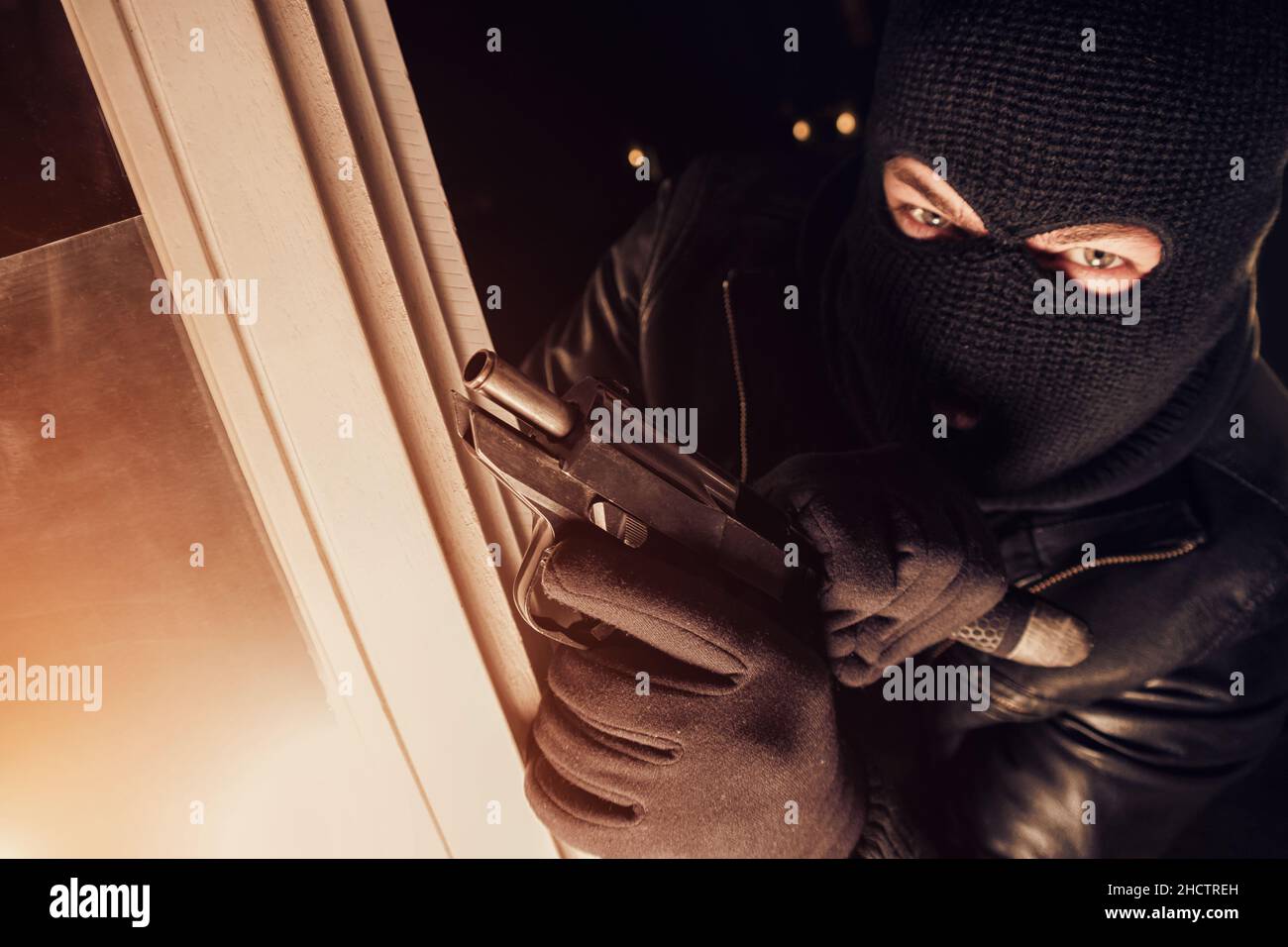 criminal burglar using gun to break into a house at night Stock Photo ...
