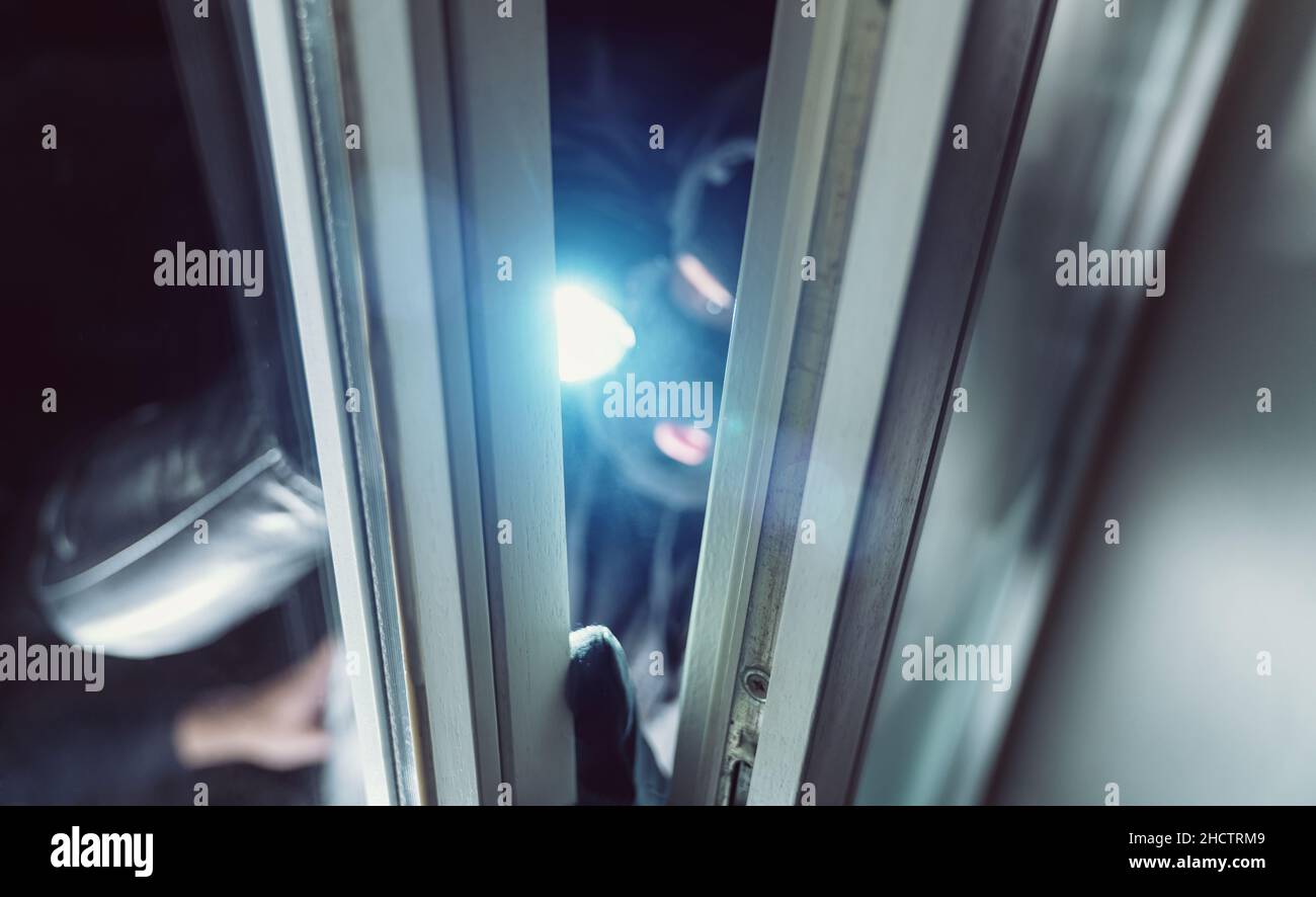 Burglar entering a house window with a crowbar Stock Photo - Alamy