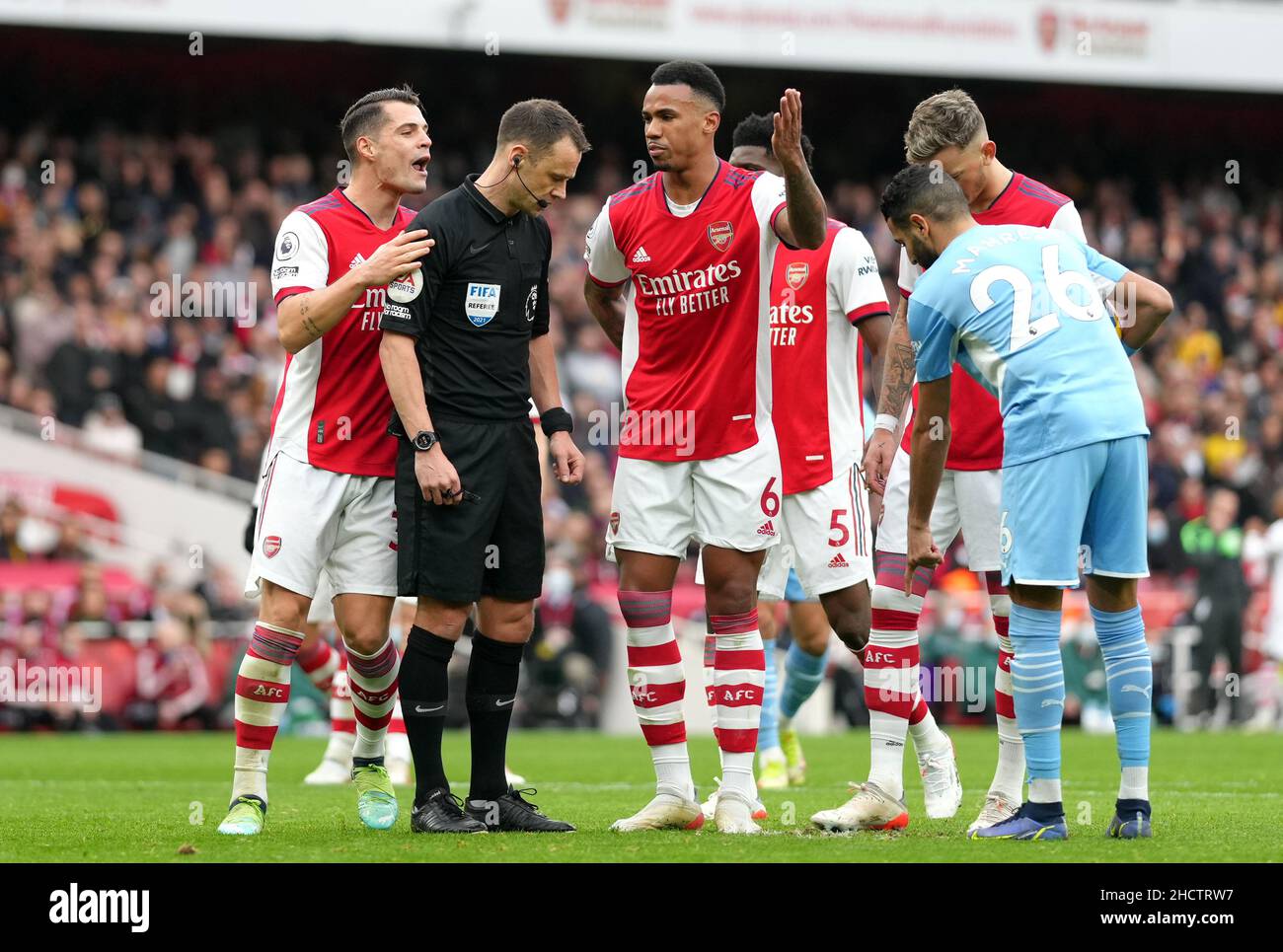Referee Stuart Attwell is surrounded by Arsenal players after awarding ...