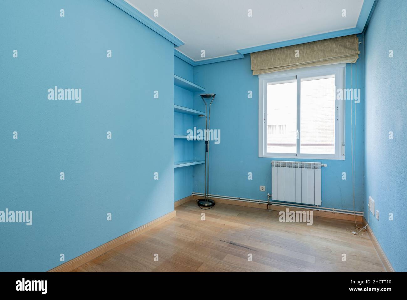 bedroom with plasterboard bookshelf and garish blue walls Stock Photo ...