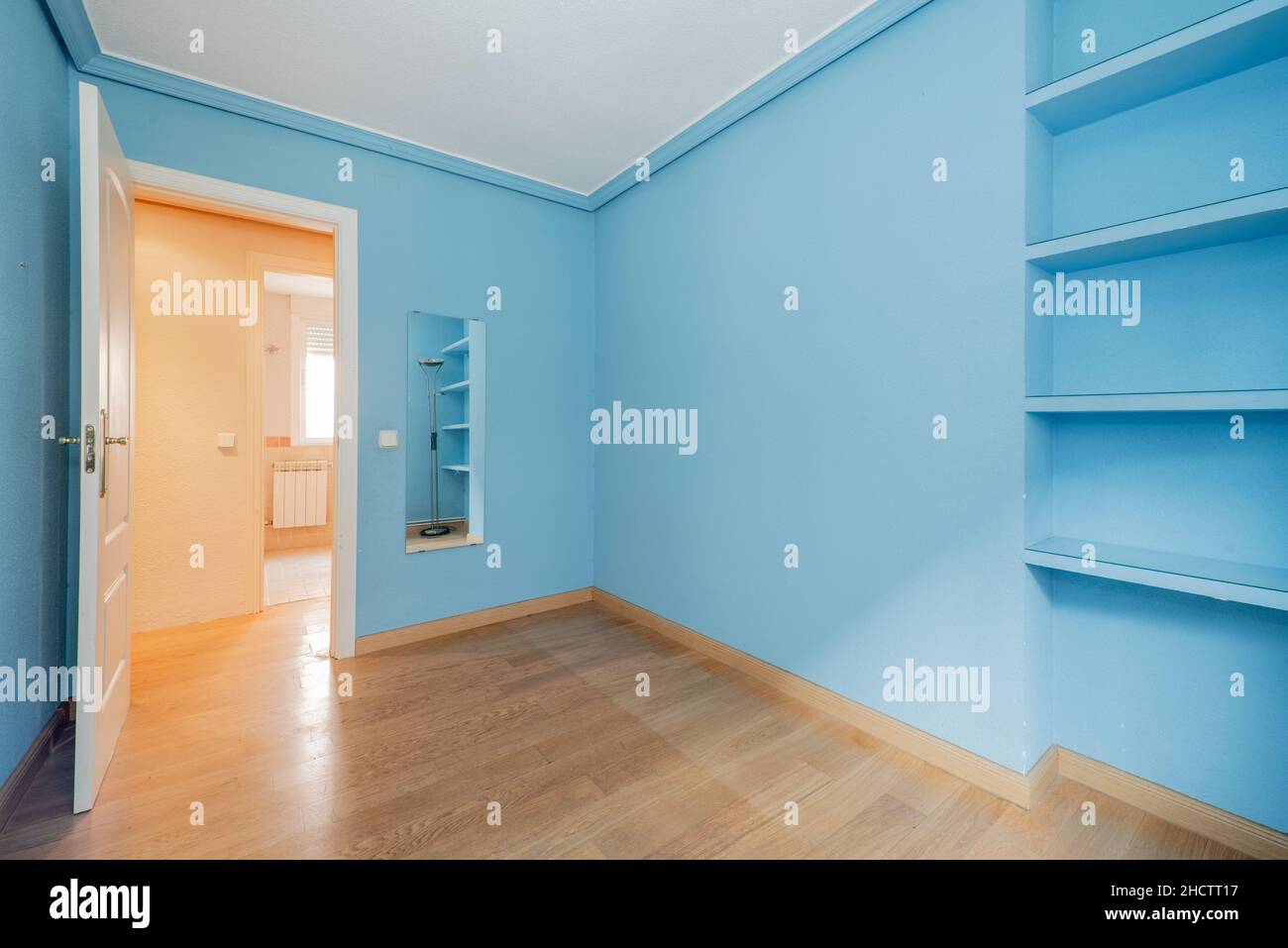 bedroom with plasterboard bookshelf and garish blue walls Stock Photo ...