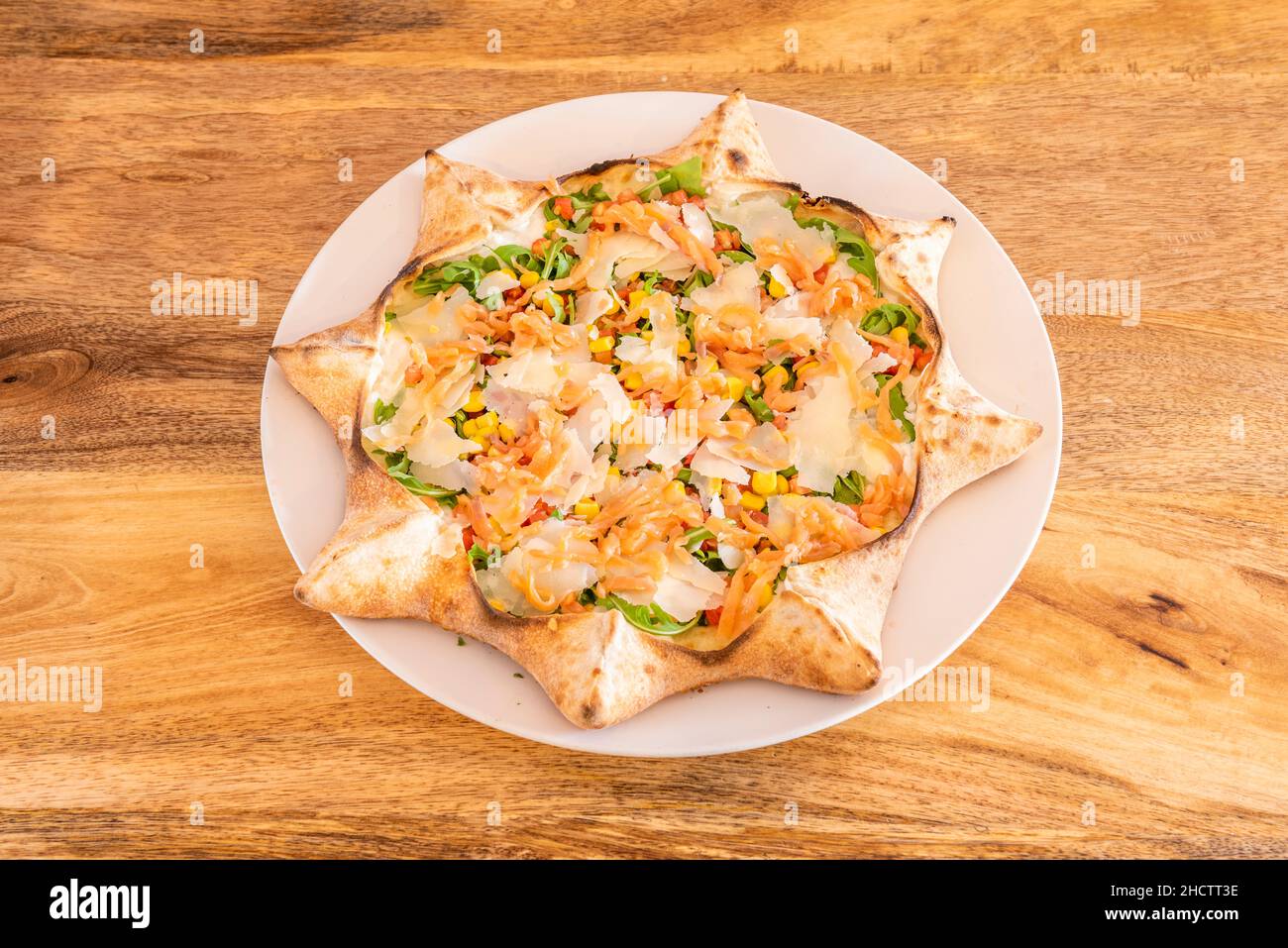 Star shaped pizza filled with vegetables, corn, crumbled Parmesan ...