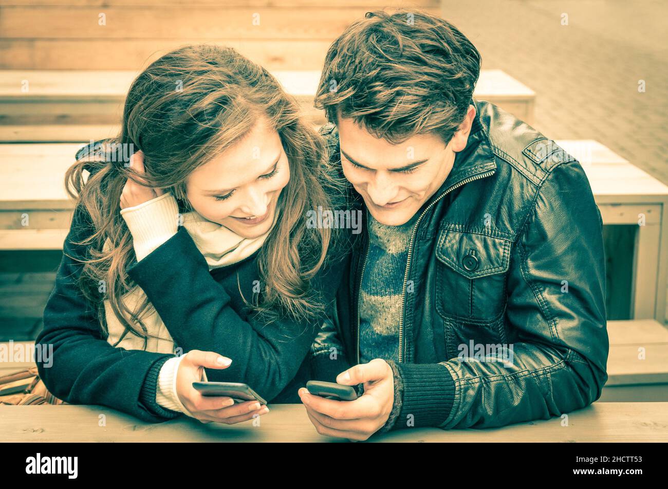 Couple in love having fun with modern phones Stock Photo - Alamy