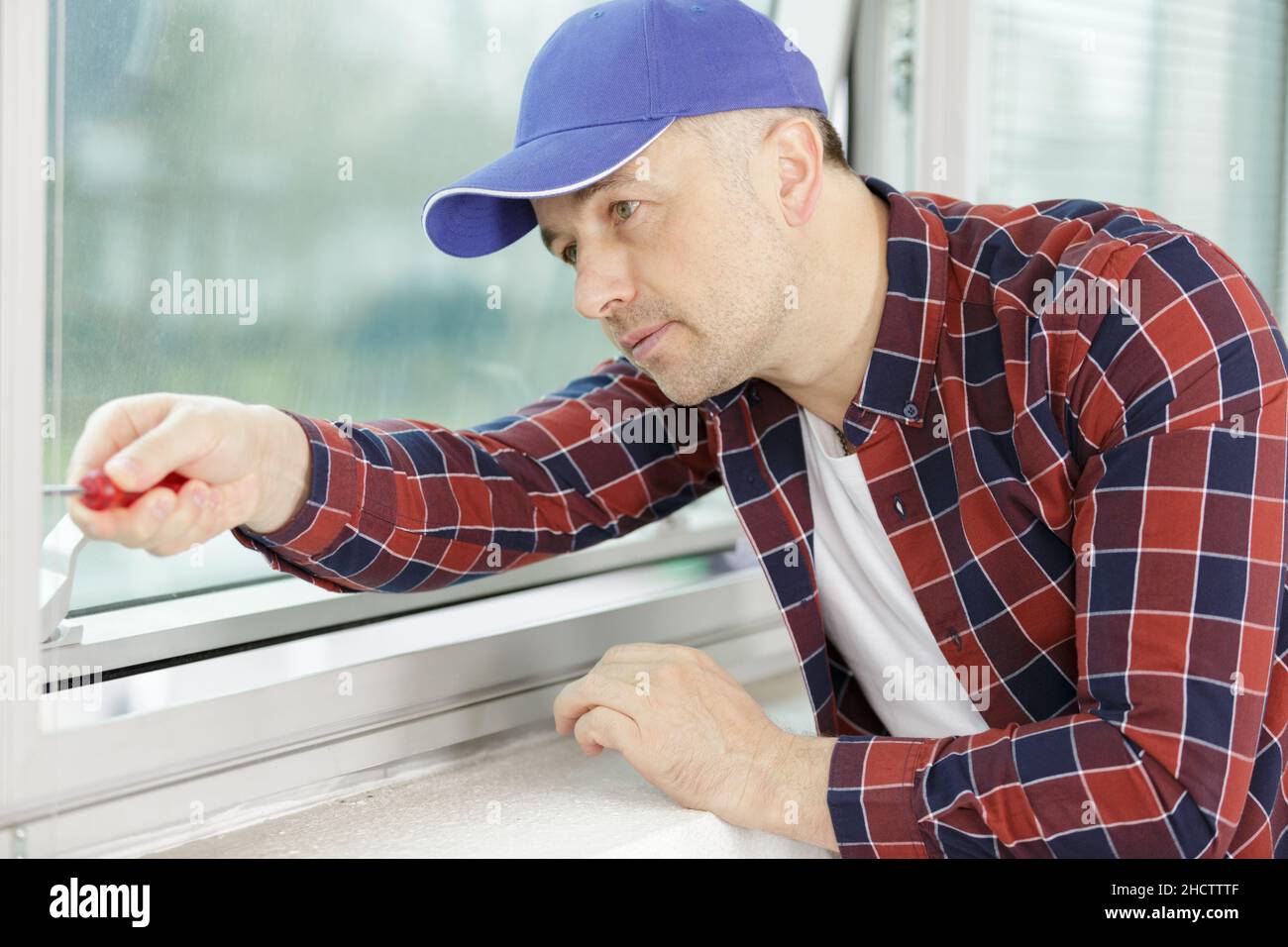 worker fasten the handle to a plastic window Stock Photo - Alamy