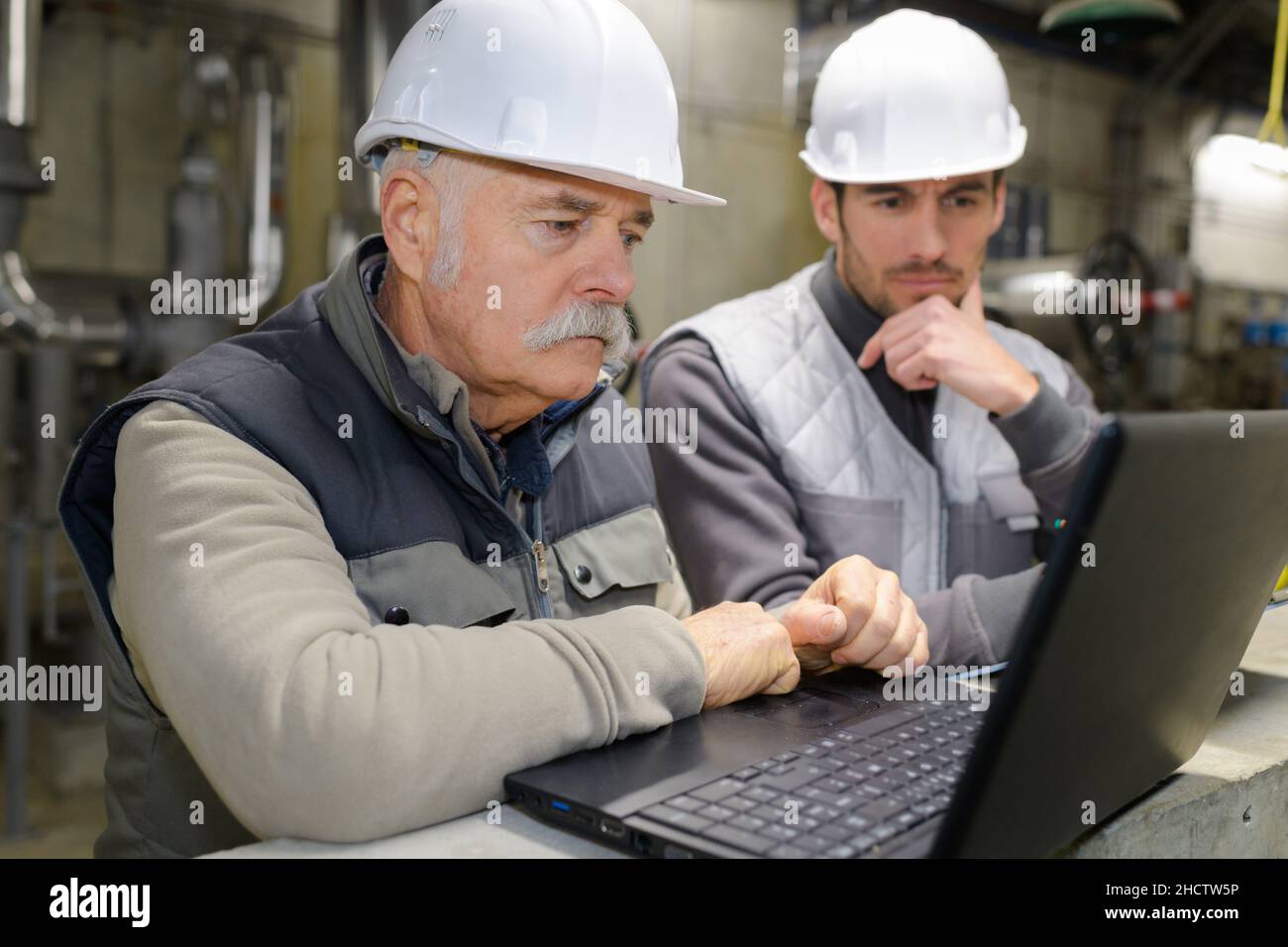 Industrial engineers working on laptop hi-res stock photography and ...