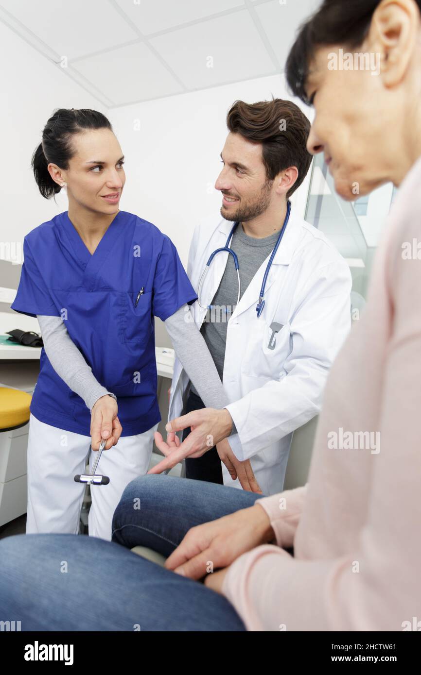 nurse trains to test knee reflexes on patient Stock Photo - Alamy