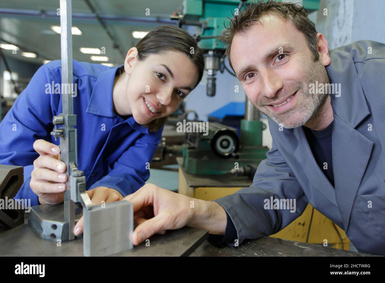 steel factory apprentice and instructor smiling Stock Photo - Alamy