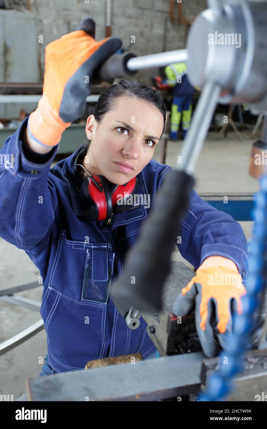 female worker turning wheel on machinery Stock Photo - Alamy