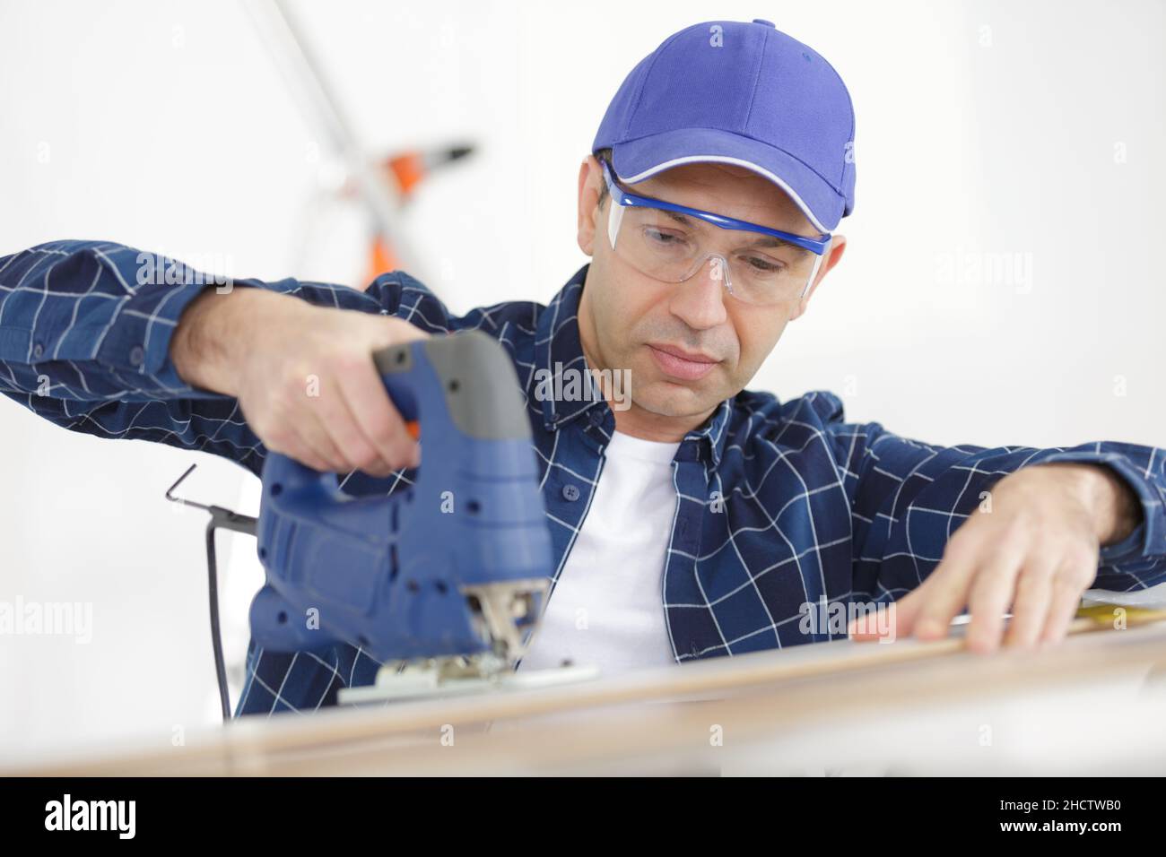 man cutting wood block with fretsaw Stock Photo - Alamy