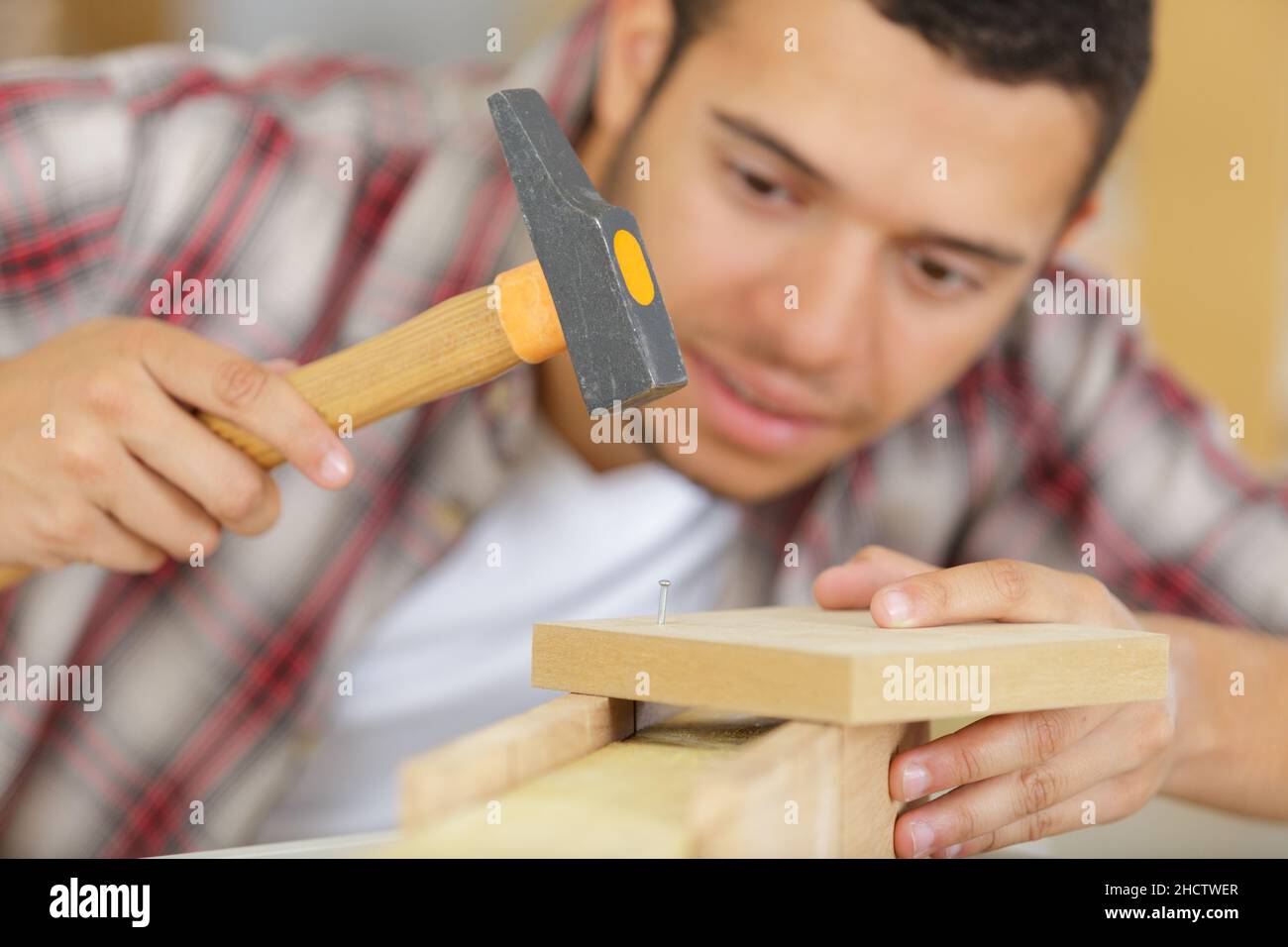 carpenter using hammer on wood Stock Photo - Alamy