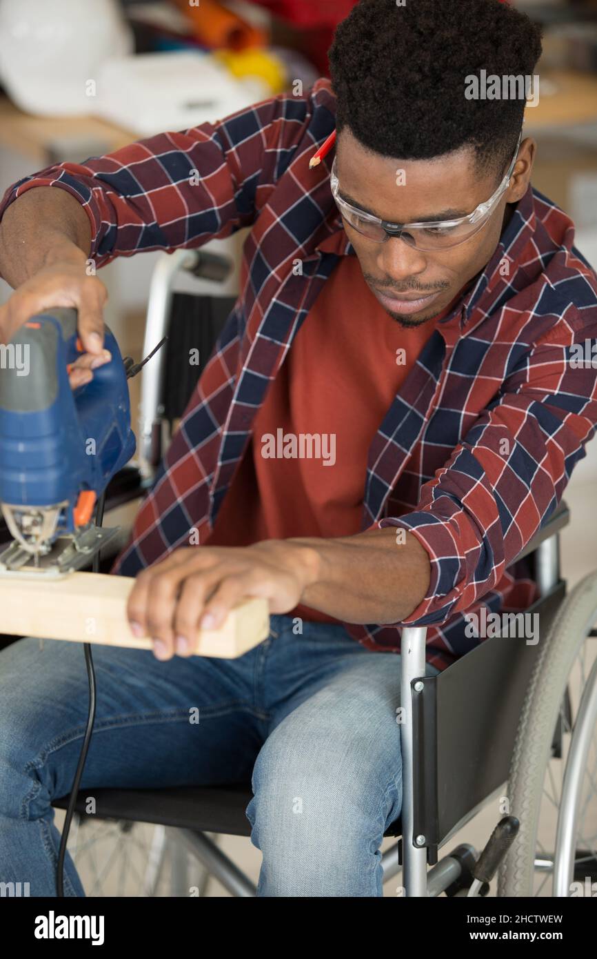 male carpenter in a wheelchair using an electric jigsaw Stock Photo - Alamy