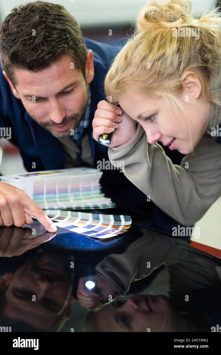 mechanic showing color samples to customer against car Stock Photo - Alamy