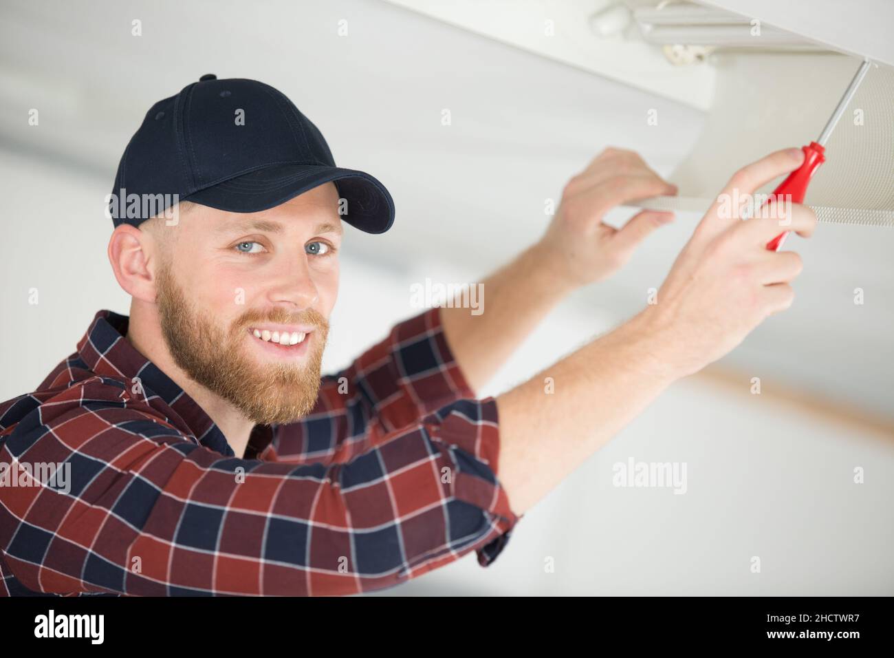 contractor unscrewing overhead ceiling panel Stock Photo - Alamy