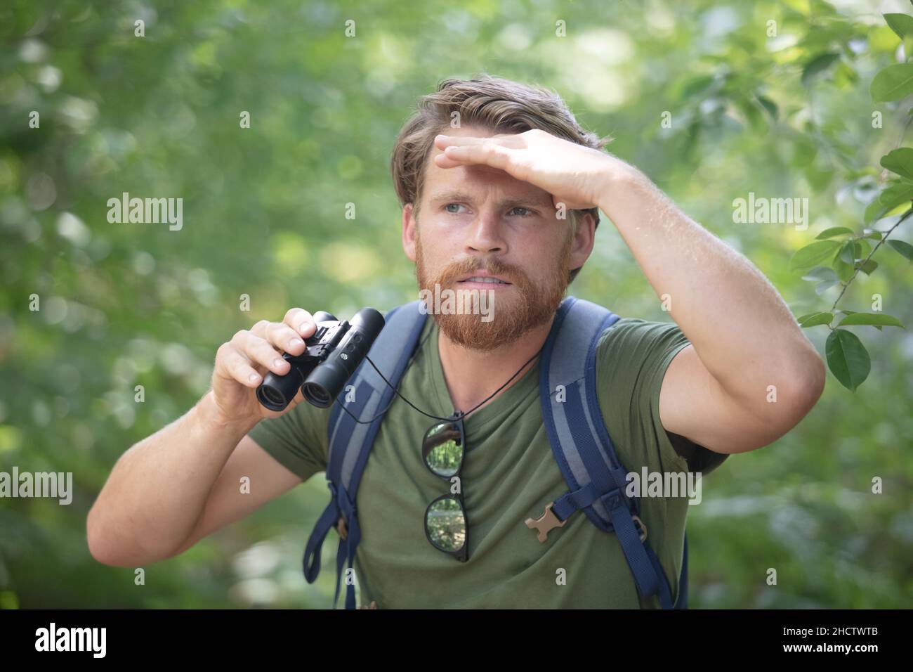 guy looking at binoculars in forest Stock Photo - Alamy